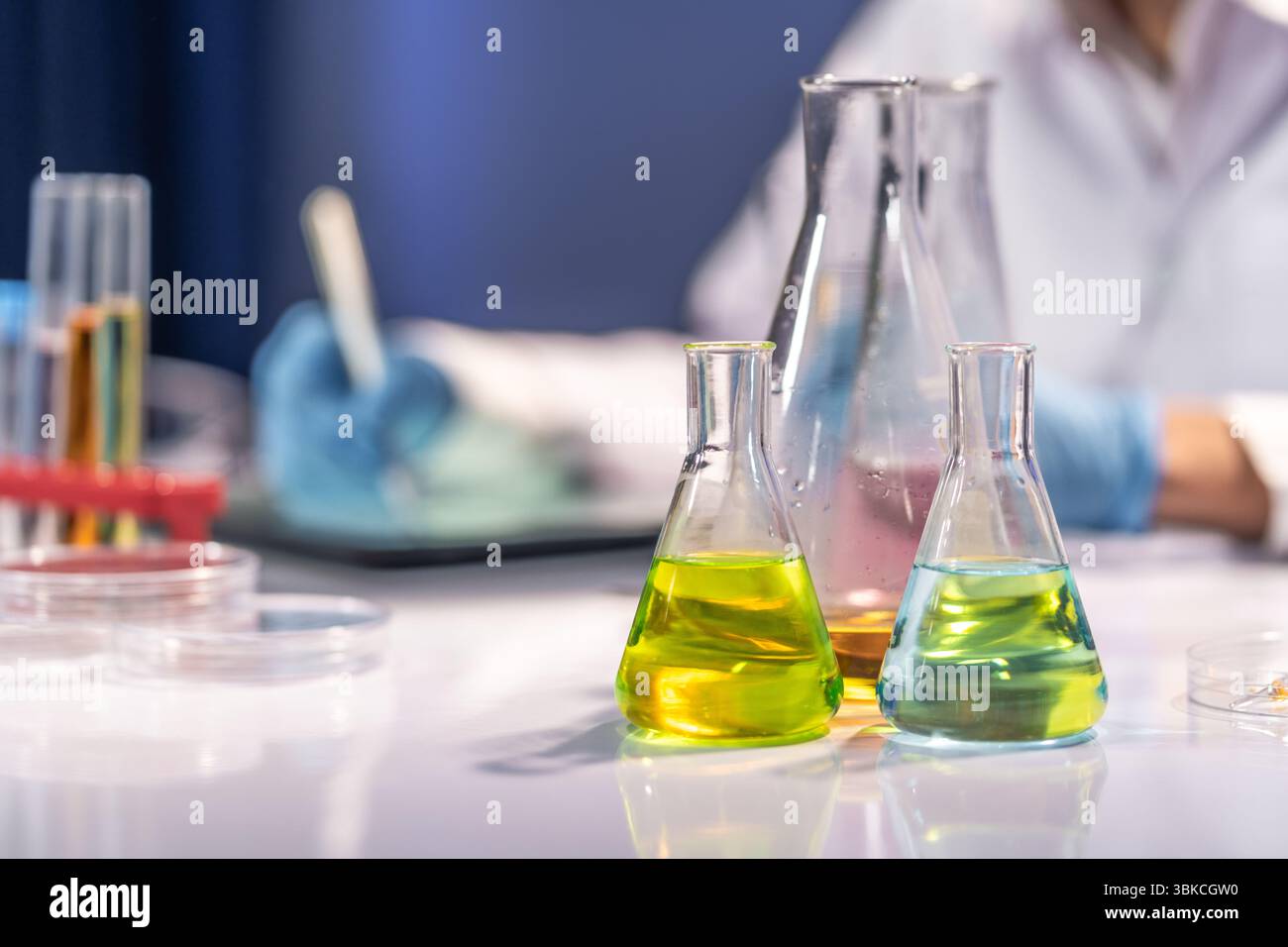 Close-up of colorful chemical liquids in Erlenmeyer flasks on a ...