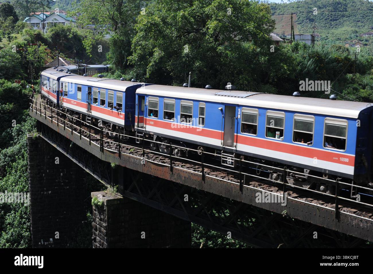 Passenger train with diesel locomotive and blue carriages crossing ...