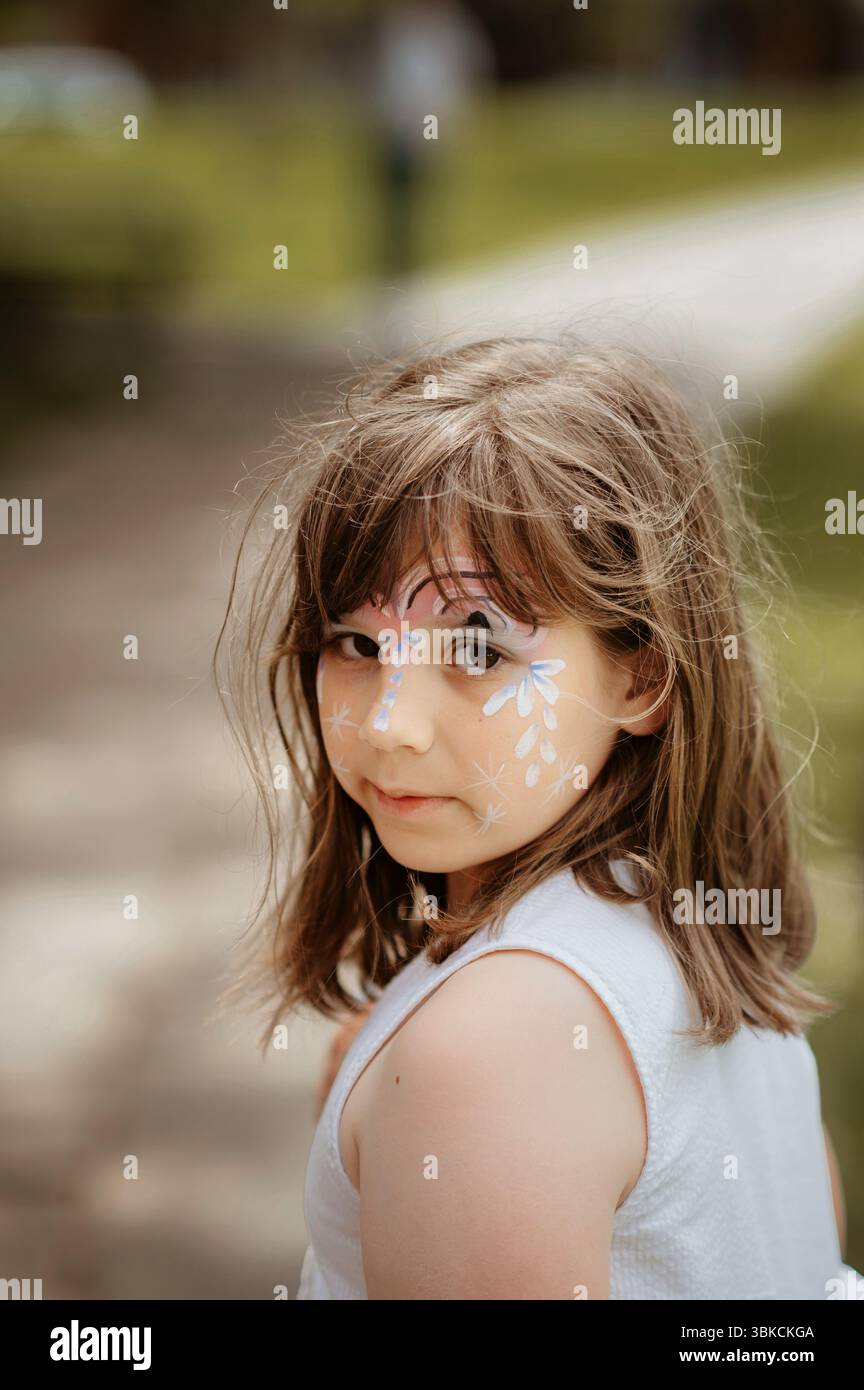 child girl with a painted face looked back Stock Photo - Alamy