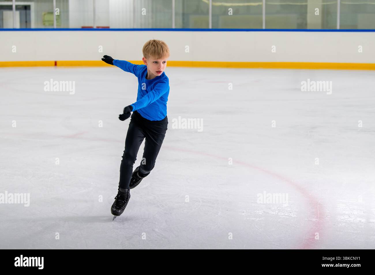 boy figure skater skates on an indoor rink, demonstrating skill Stock ...