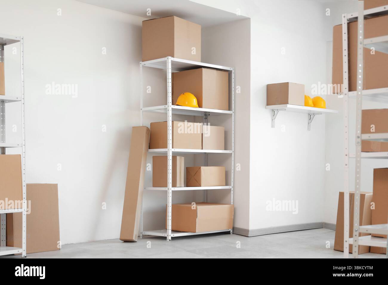Interior of light warehouse with shelf unit, cardboard boxes and ...