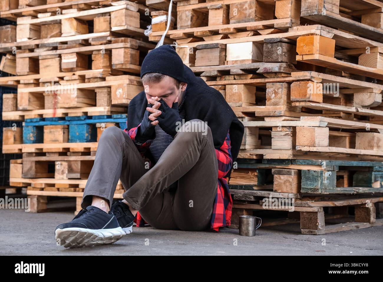 Frozen homeless man sitting on street Stock Photo - Alamy