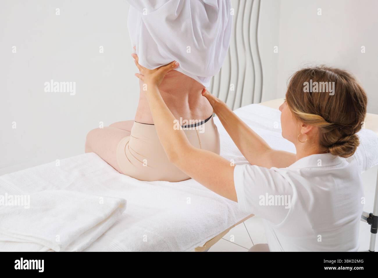 Rehabilitation specialist supports woman with scoliosis or spine injury ...