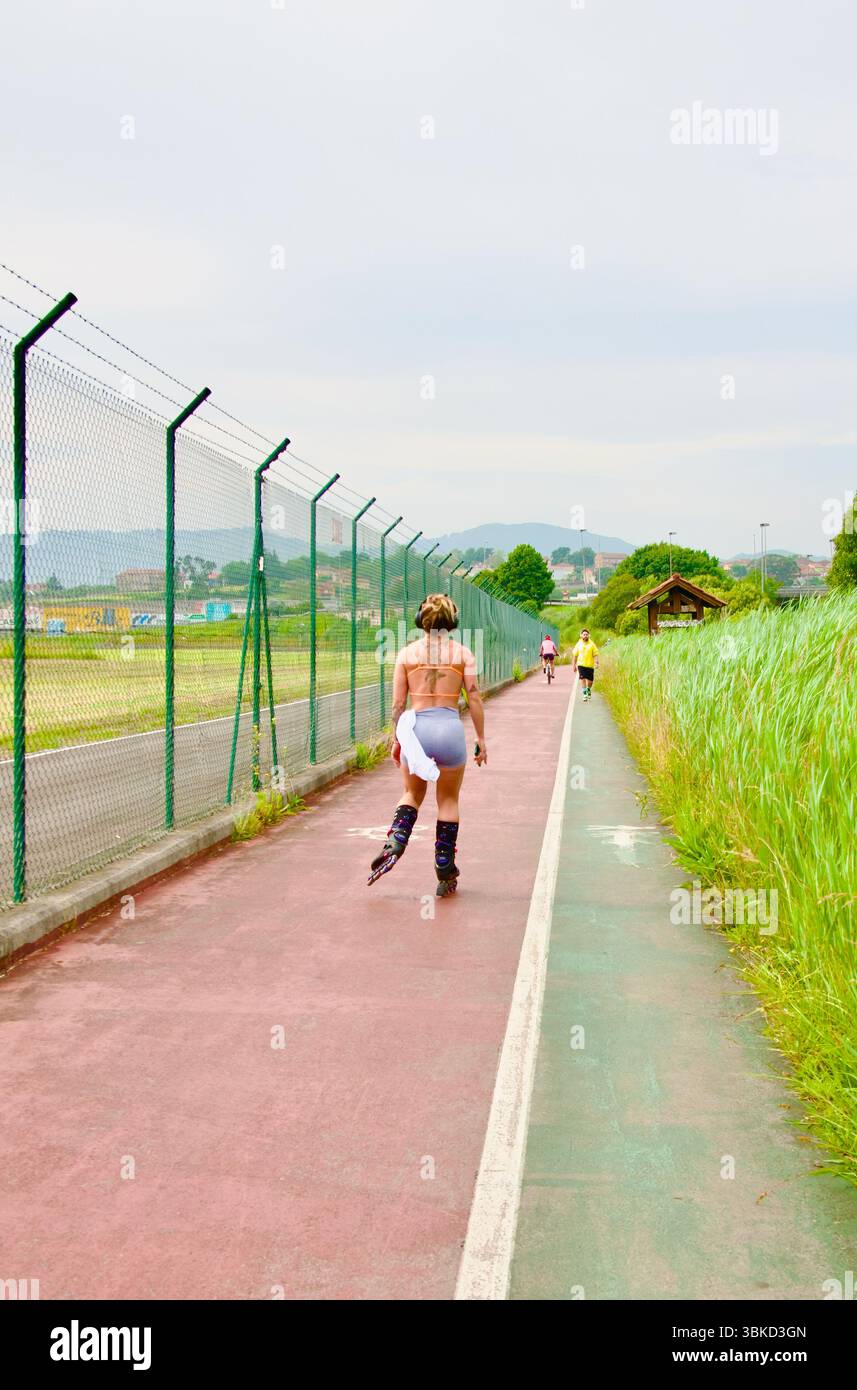 Woman rollerblading along the cycle path and walking path next to the ...