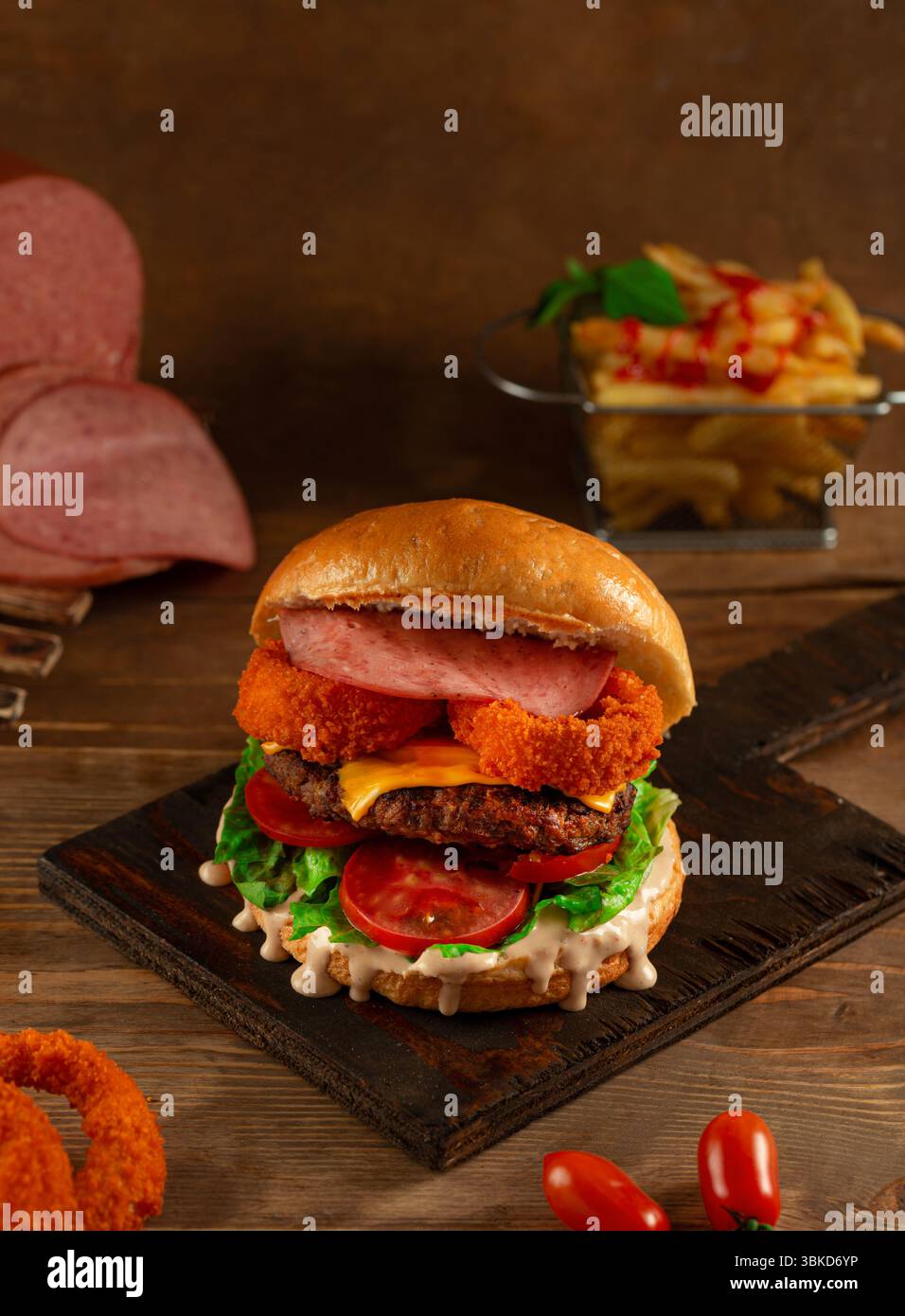 Classic burger with salami ranch sauce onion rings and large beef patty ...