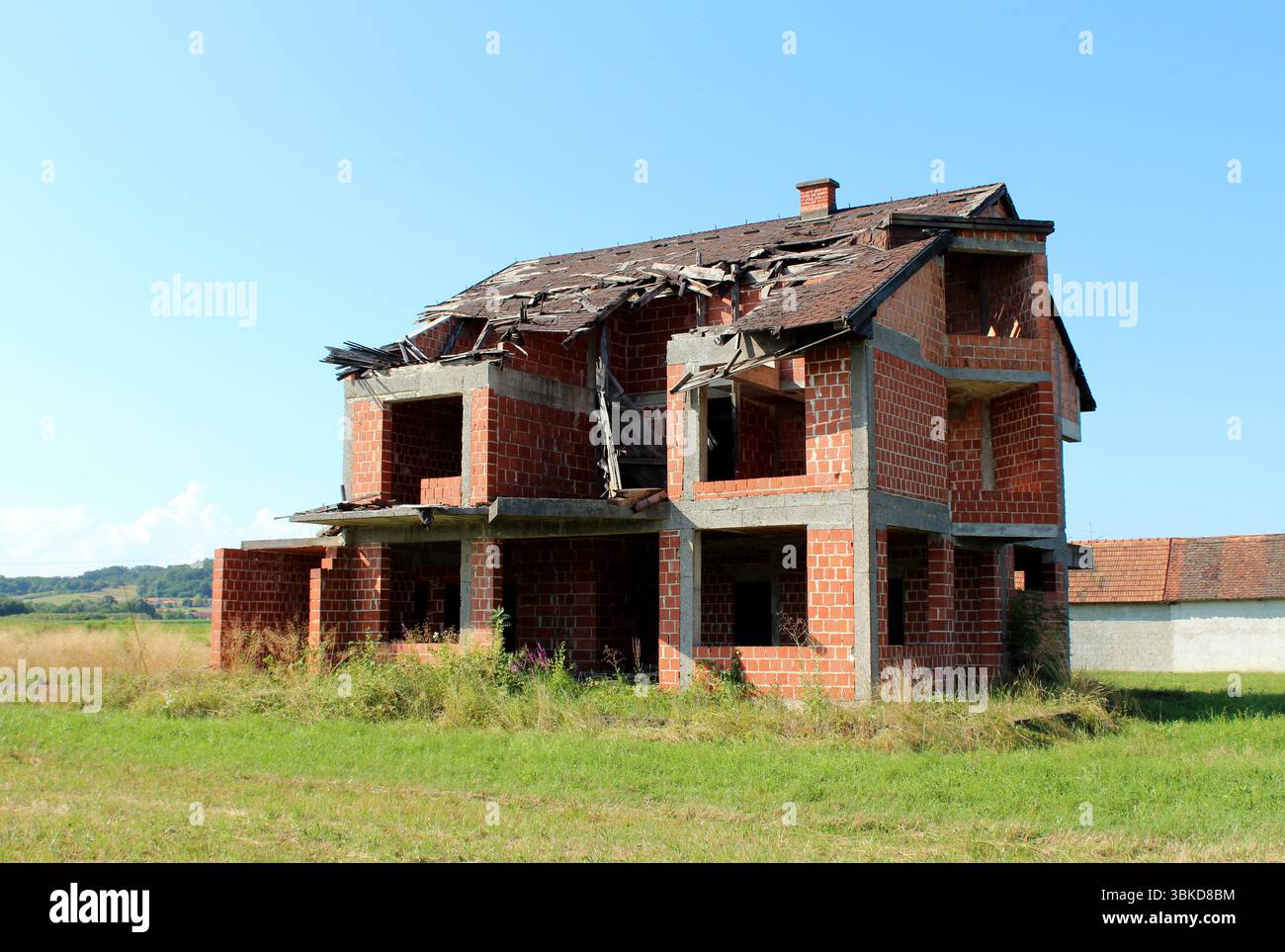 Unfinished two-story brick house with a partially collapsed roof and ...