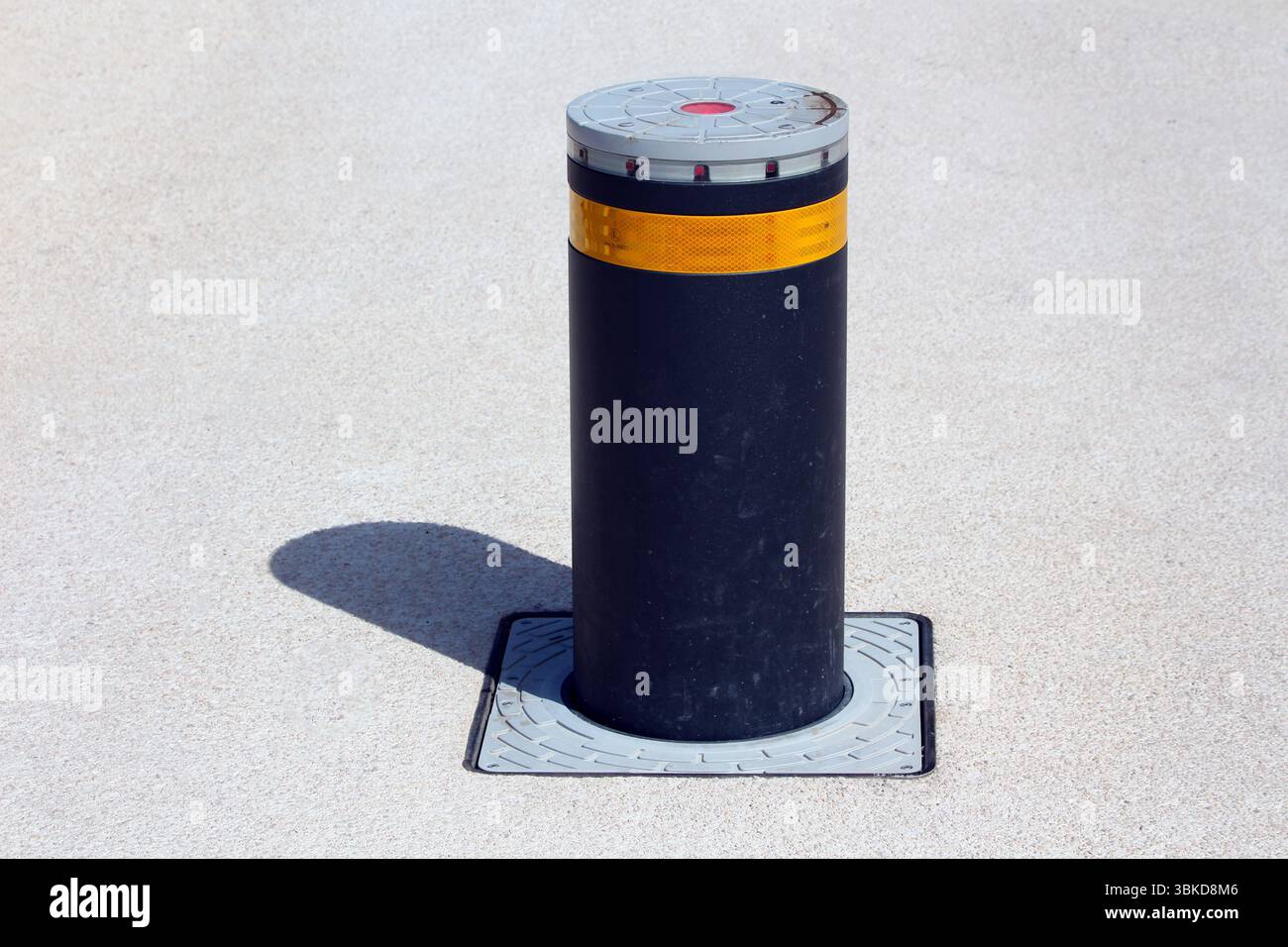 Black retractable traffic bollard with a yellow reflective band and ...