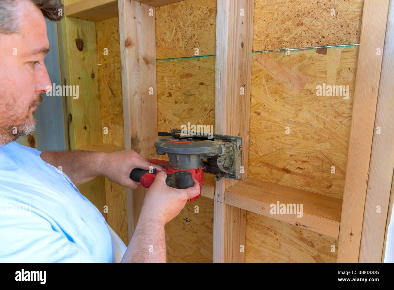 Woodworker uses saw cut router to shape wooden panels in home workshop ...