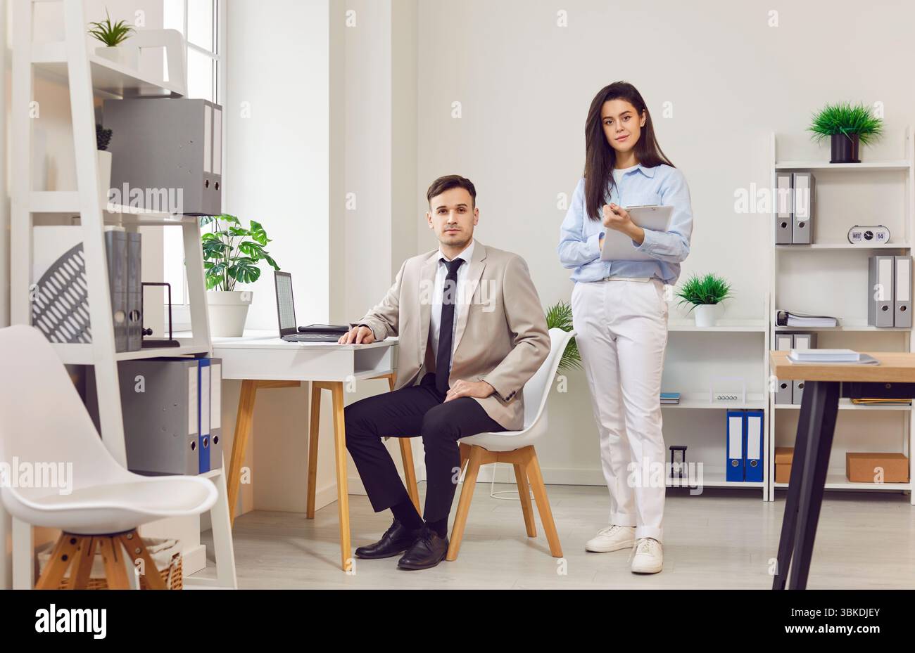 Young positive business office male, female colleagues posing at desk ...