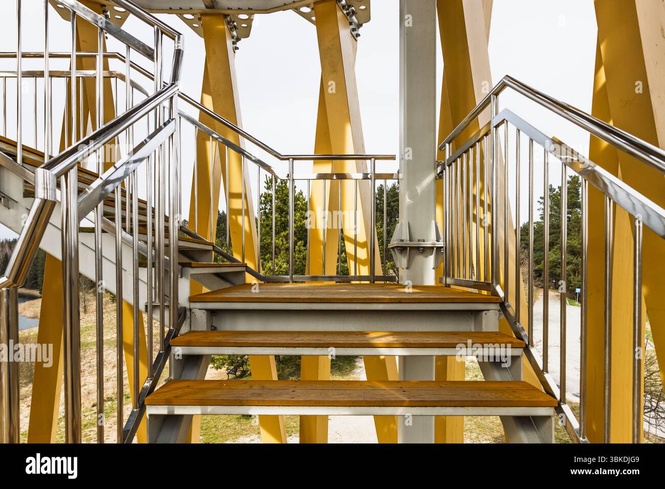 Low angle shot of yellow steel supports and metal stairs ascending to a ...