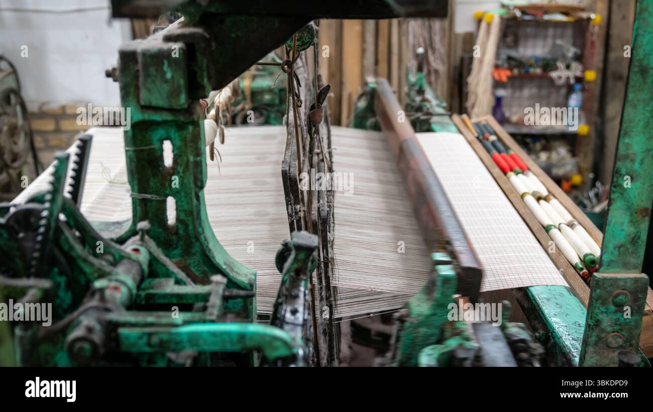 Close-up of a vintage textile weaving loom in operation, showing ...