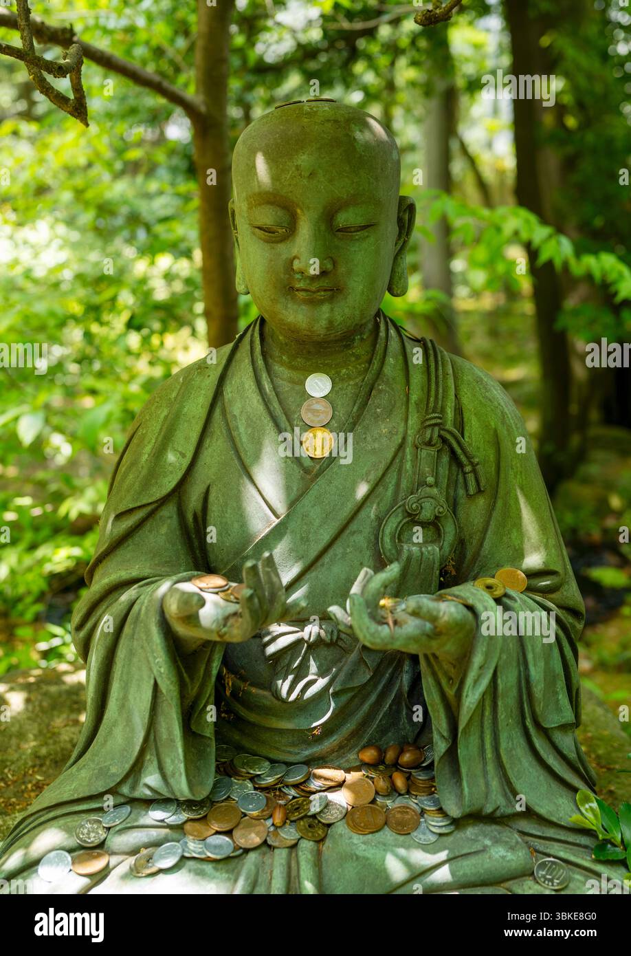 Statue of Buddha taken in Japan. The Buddha has coins on it for good ...