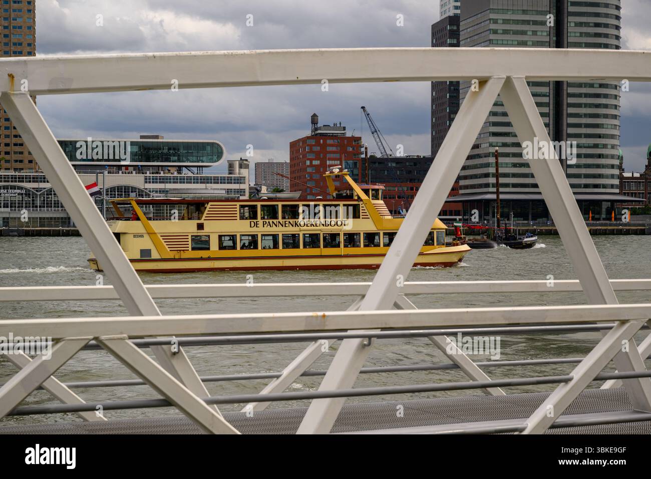 A yellow Pannenkoekenboot sailing down the Nieuwe Maas river, Rotterdam ...