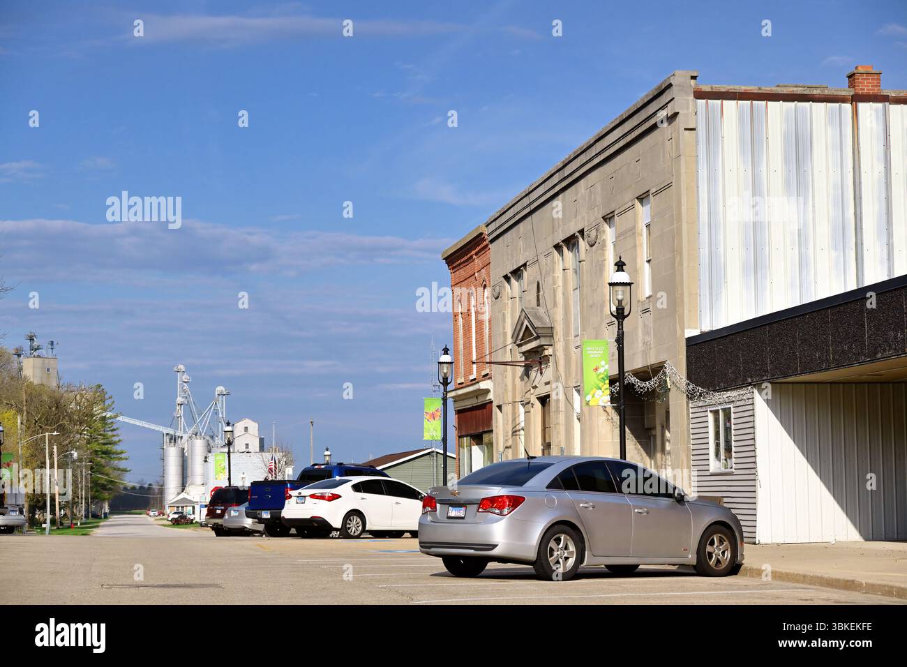 Earlville, Illinois, USA. Vehicles line one side of a street in a very ...