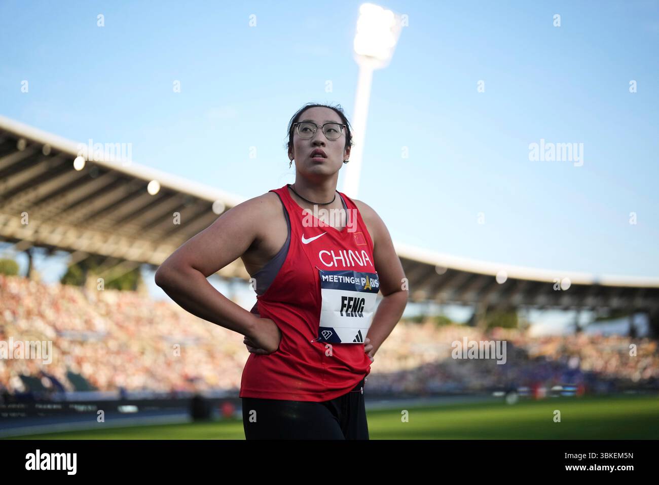 Feng Bin, of China, looks on between attempts in the women discus throw ...