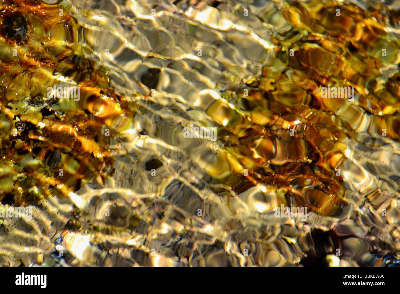 Light passing through moving water creating an abstract image of gold ...
