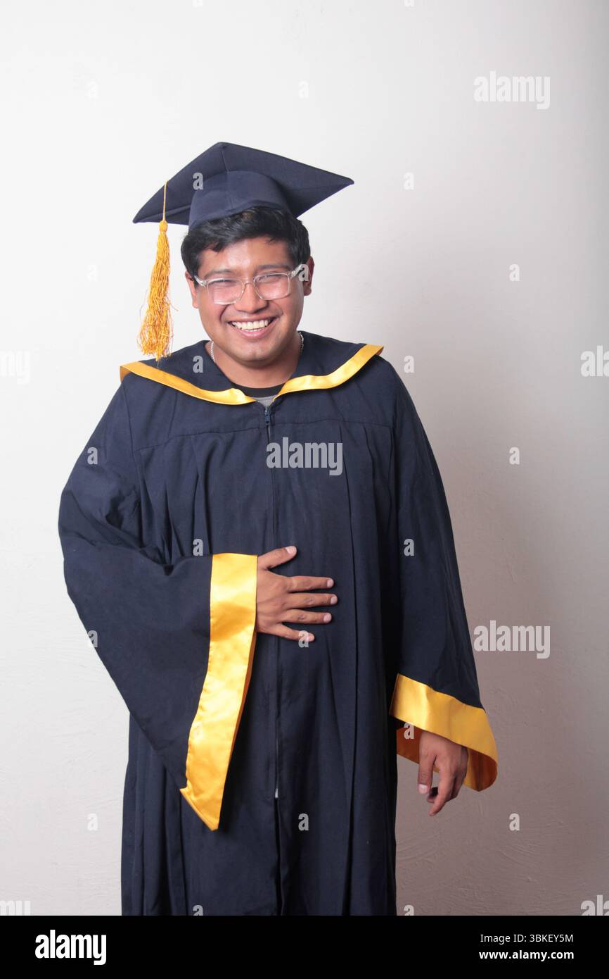 30-year-old dark-skinned Latino man with glasses wears a cap and gown ...