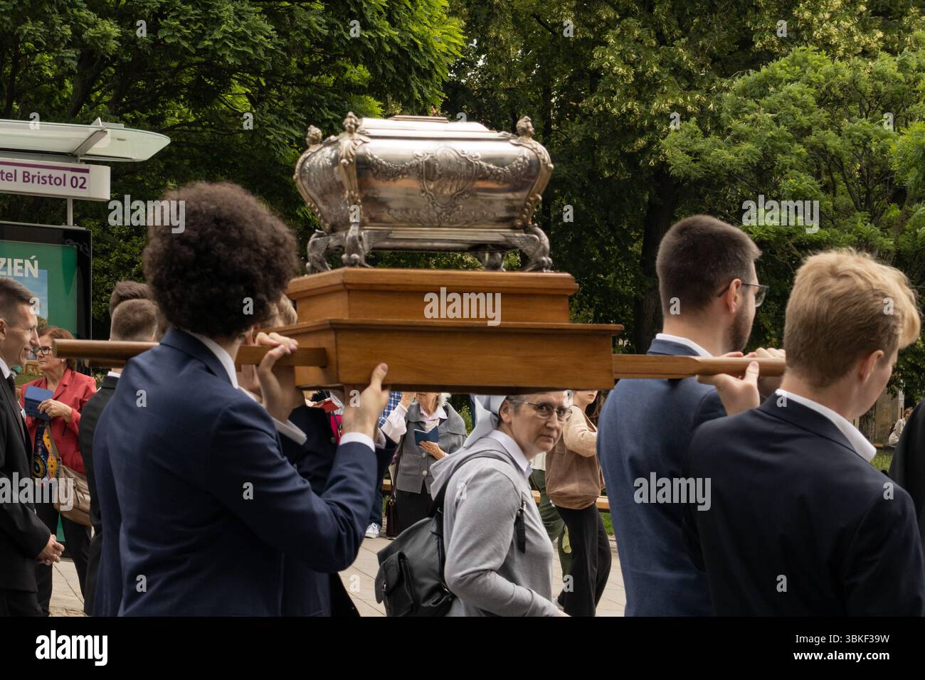 A group of Catholic worshippers, mainly men carrying a silver ...