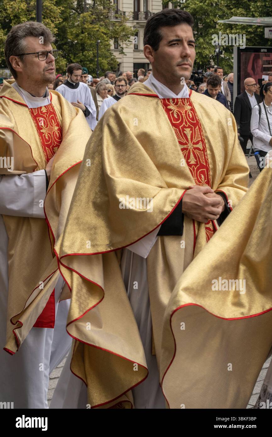 A group of Catholic priests and parishioners wearing golden liturgical ...