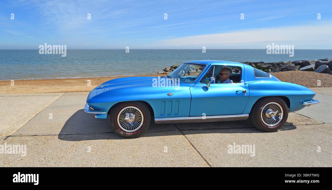 Classic Chevrolet Corvette C2 being driven on seafront promenade beach ...