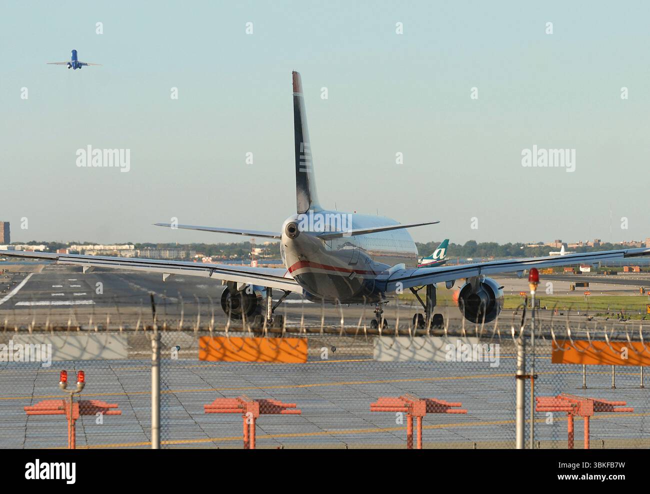 FILE - An aircraft takes off while another waits at LaGuardia Airport ...