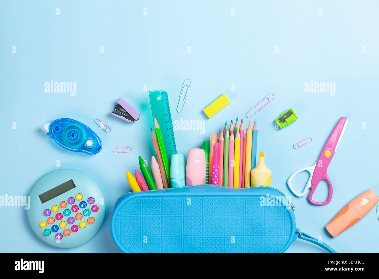 Blue pencil case with school supplies on light blue background. Back to ...