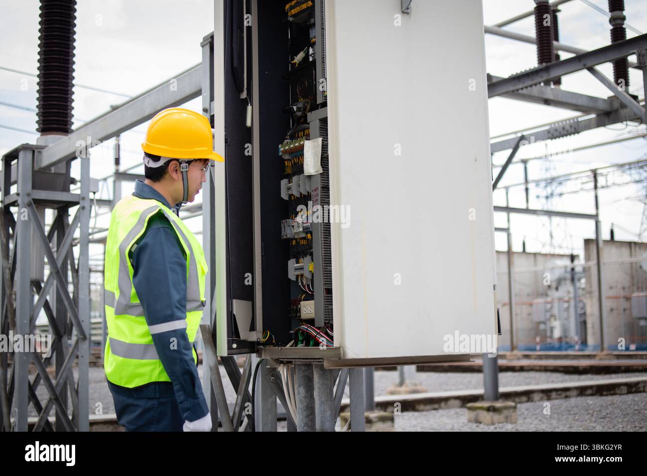 An engineer working at high voltage substation inspecting electrical ...