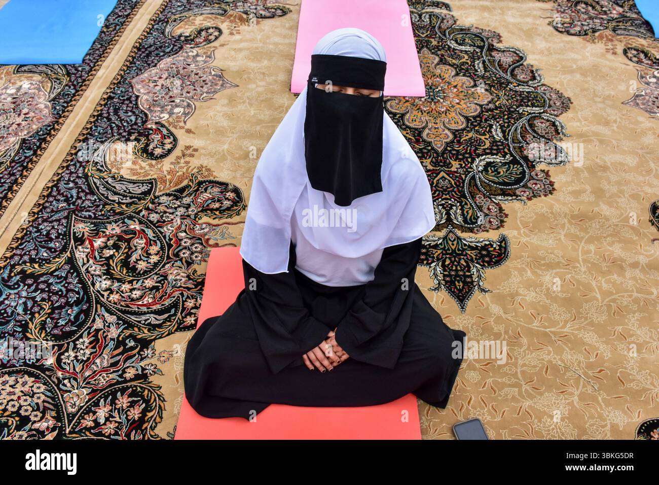 A Kashmiri student performs yoga during a mass yoga session on ...