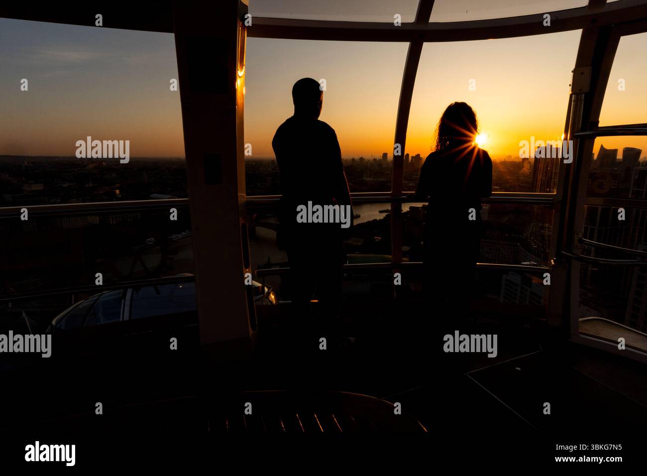 People watch the sun rise from a pod on the london eye during the ...