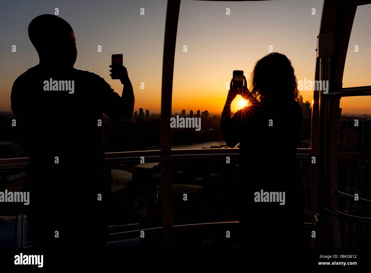 People watch the sun rise from a pod on the london eye during the ...