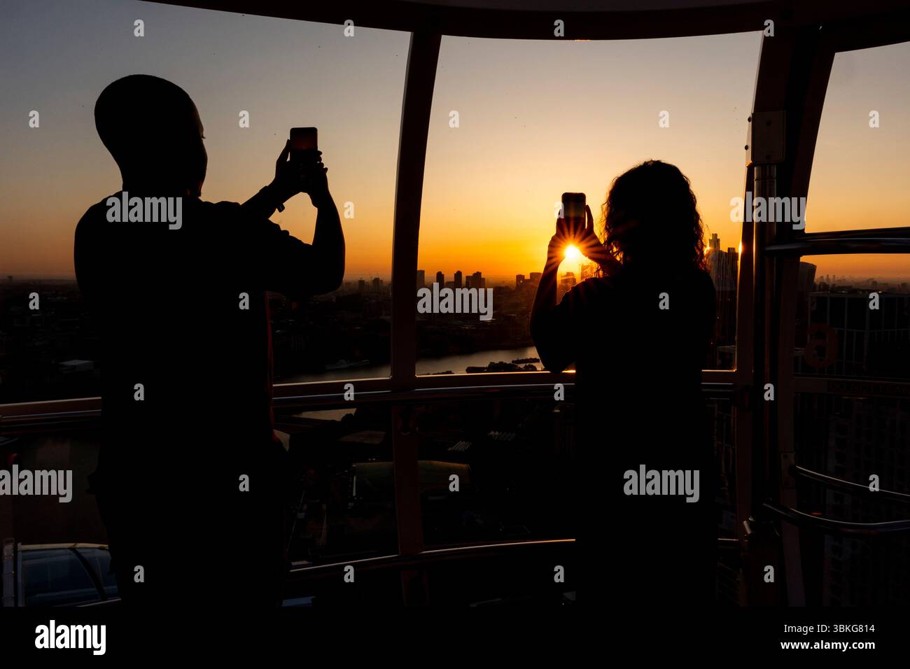 People watch the sun rise from a pod on the london eye during the ...