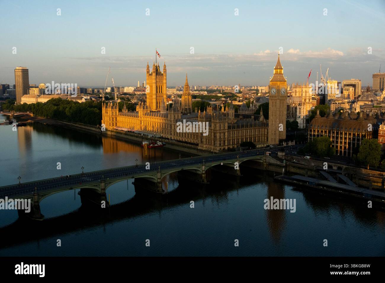 The sun rises over the houses of parliament in london, viewed from a ...