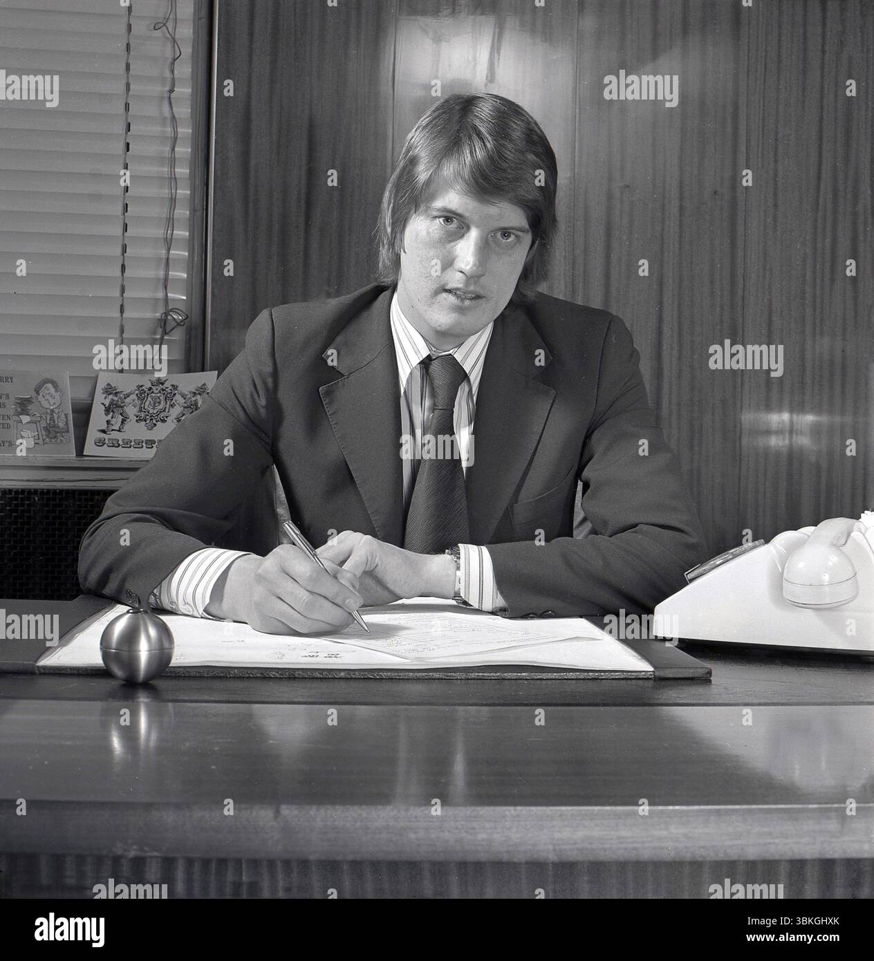 1970s, historical, in an office, a young business executive, mid 30s in ...