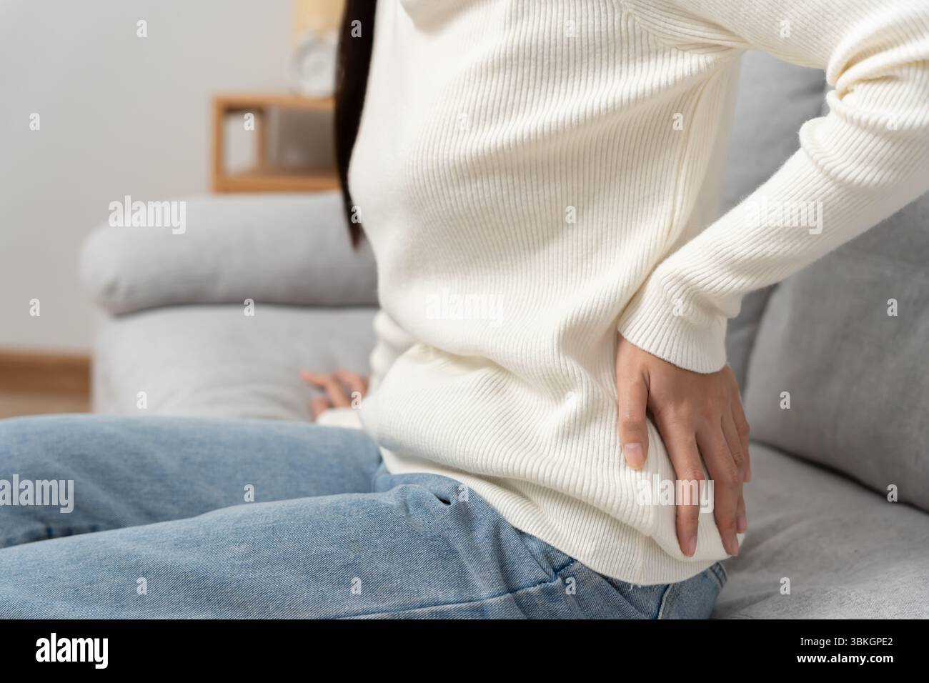 woman holding her lower back while and suffer from unbearable pain ...