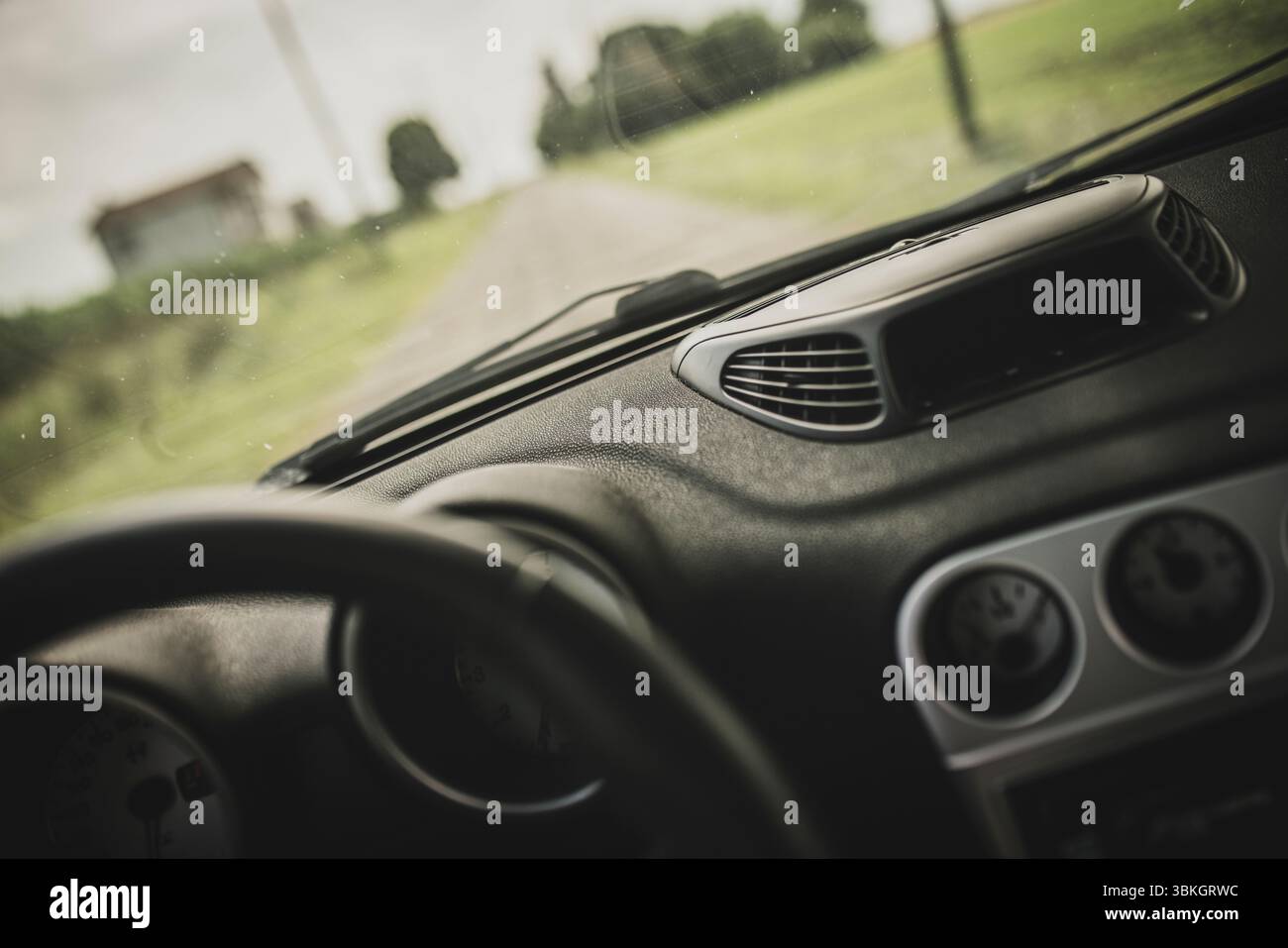 Dashboard view of a car driving on a country road, showing the steering ...