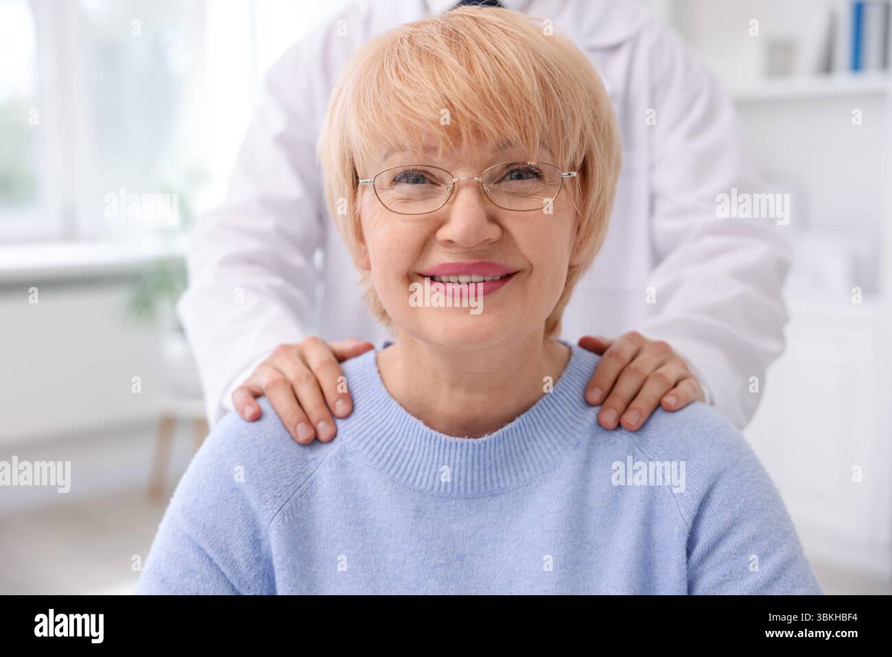 Professional ophthalmologist and patient with glasses in clinic ...