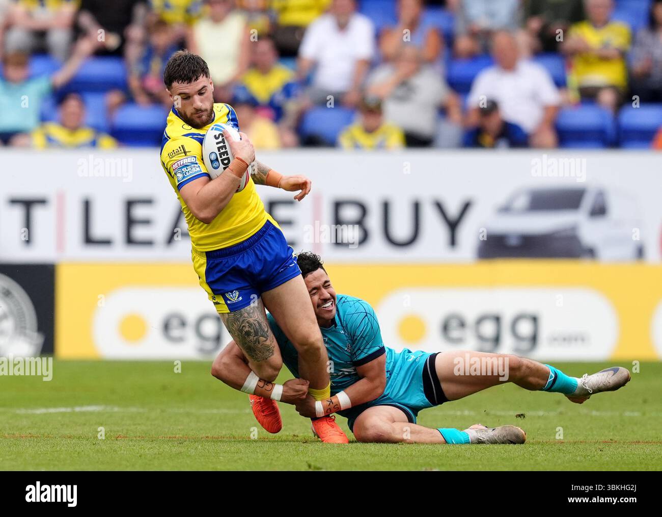 Warrington Wolves' Connor Wrench is tackled by Huddersfield Giants ...