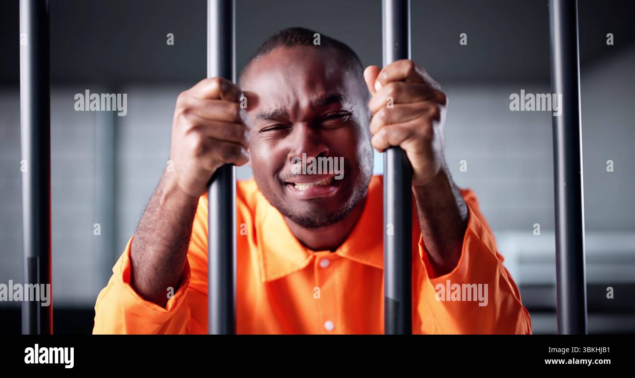 The Sad, Crying Prisoner Behind Bars In A Jail Cell Stock Photo - Alamy