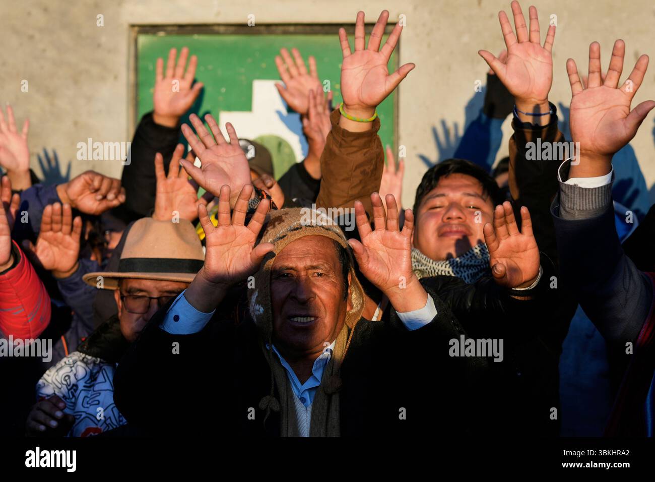Aymara Indigenous people hold up their hands to receive the first rays ...
