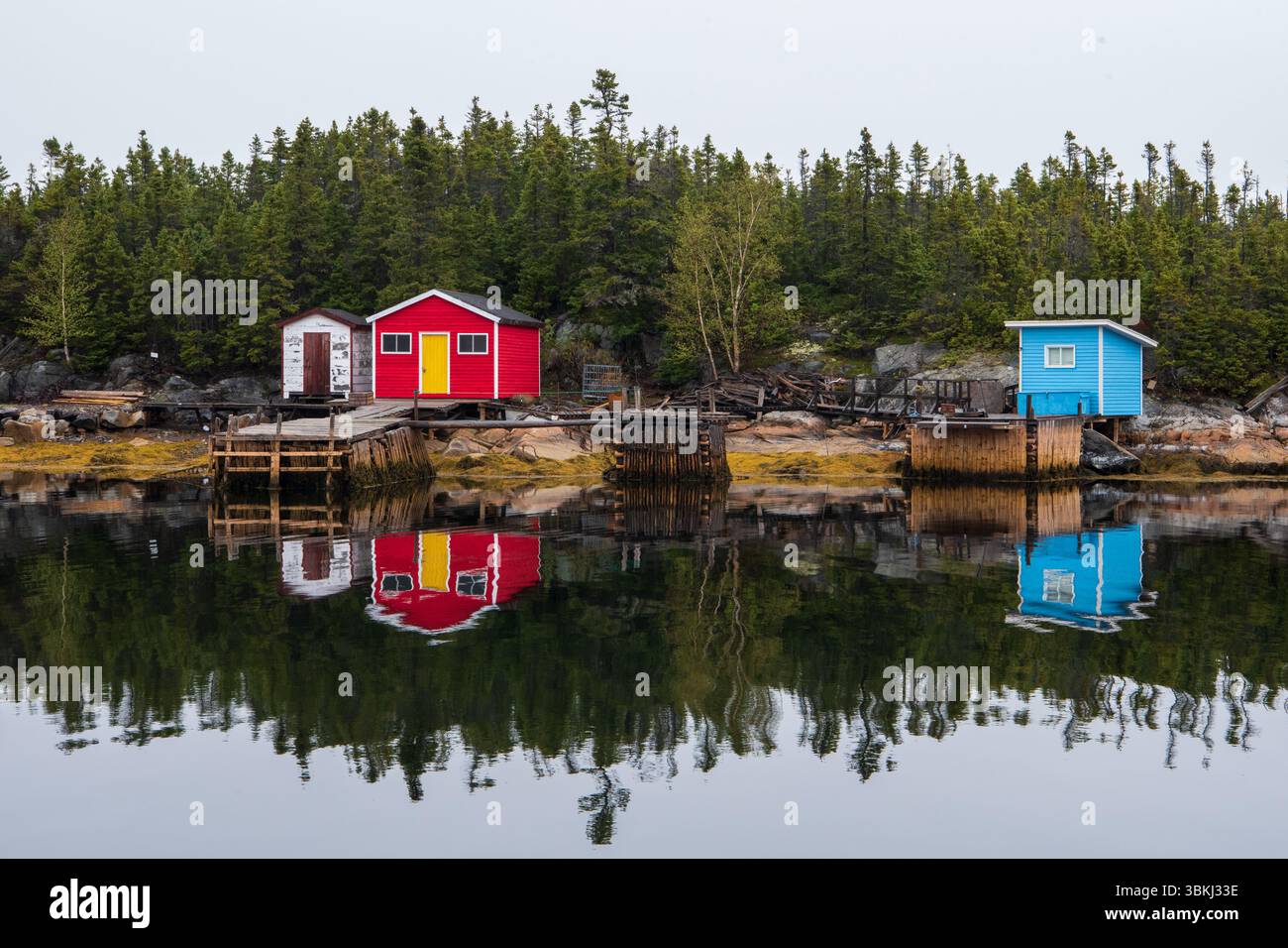 Colorful fishing huts are reflected in the calm waters of the Southern ...