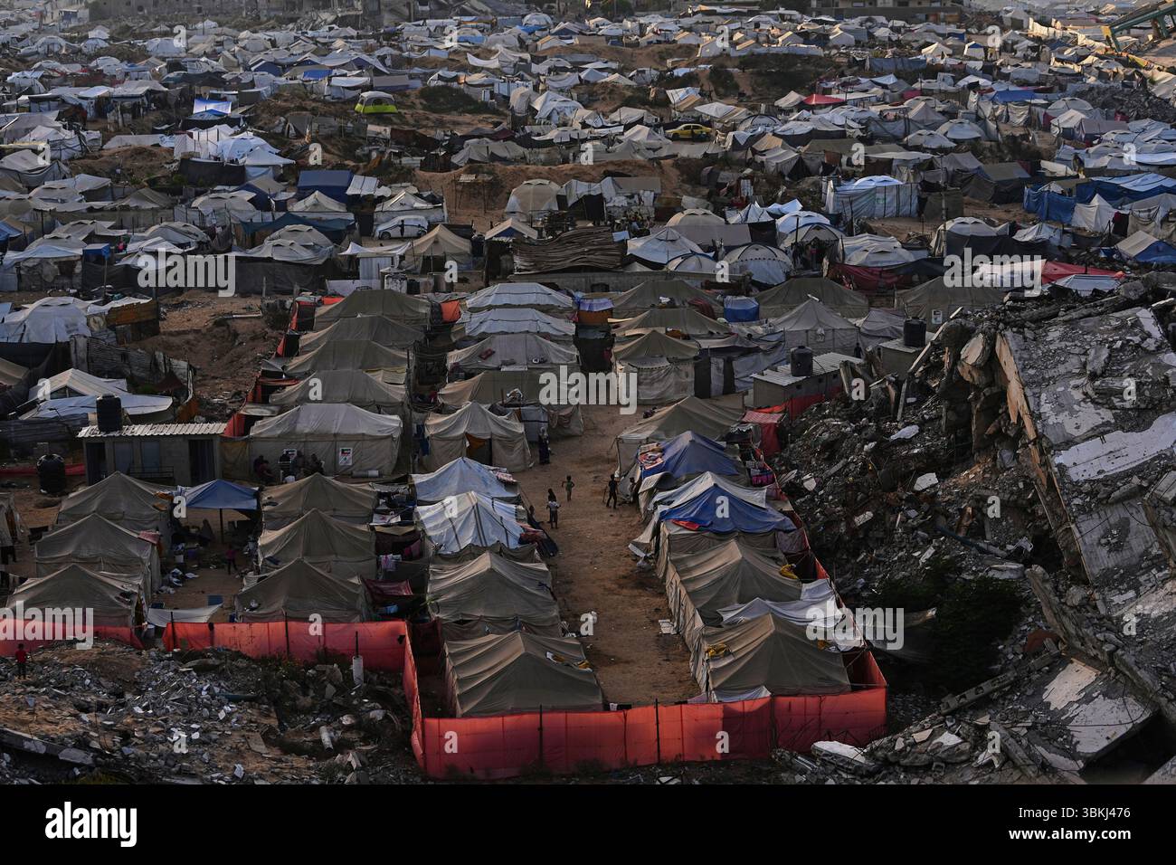 A tent camp for displaced Palestinians stretches among the ruins of ...