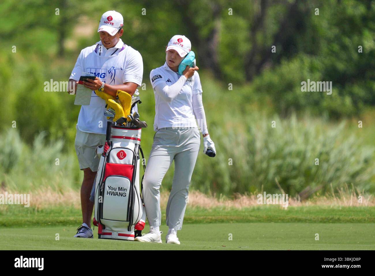 Youmin Hwang, of South Korea, uses an ice pack to cool off alongside ...