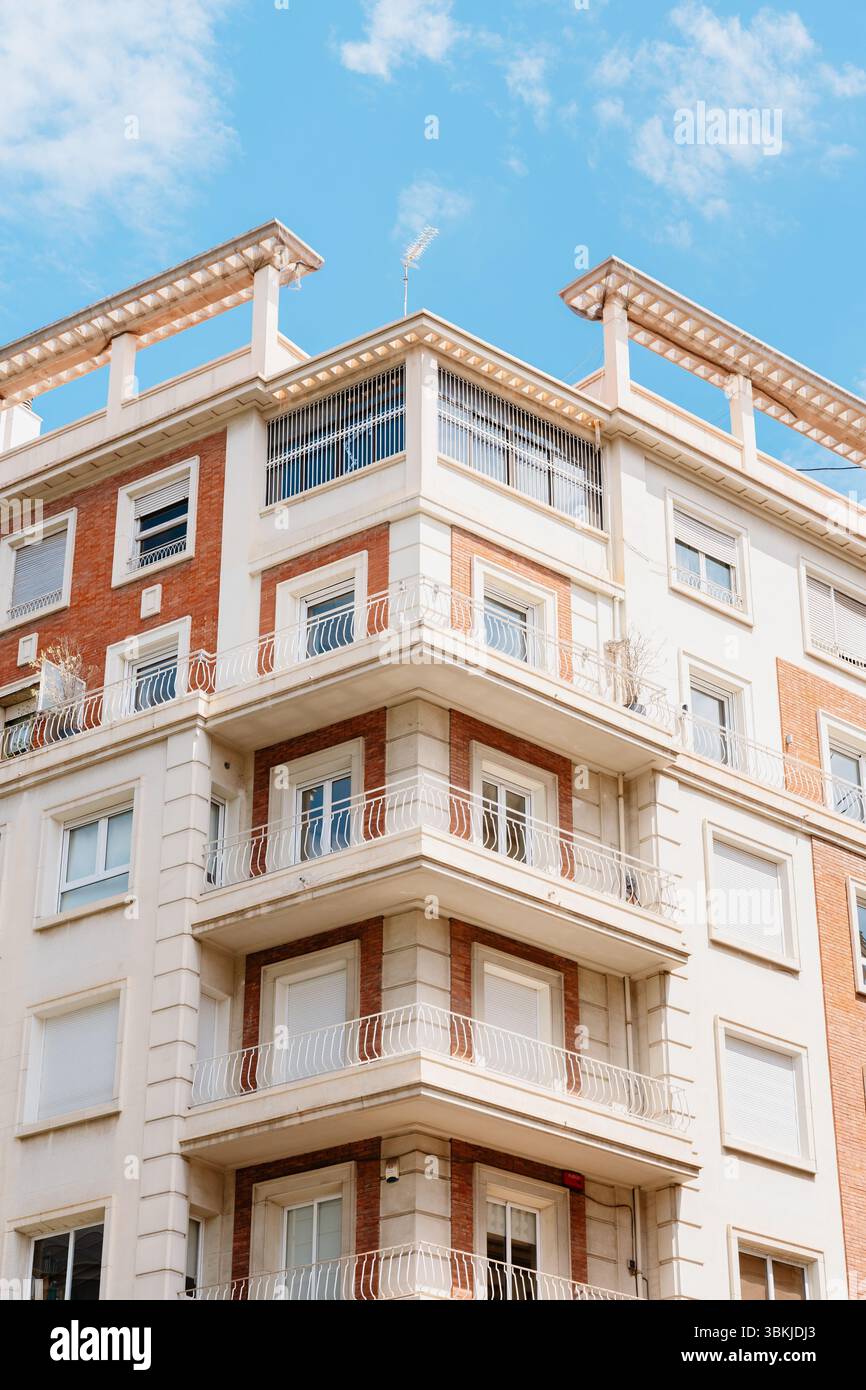 Residential building with red-brick and cream walls, balconies, and ...