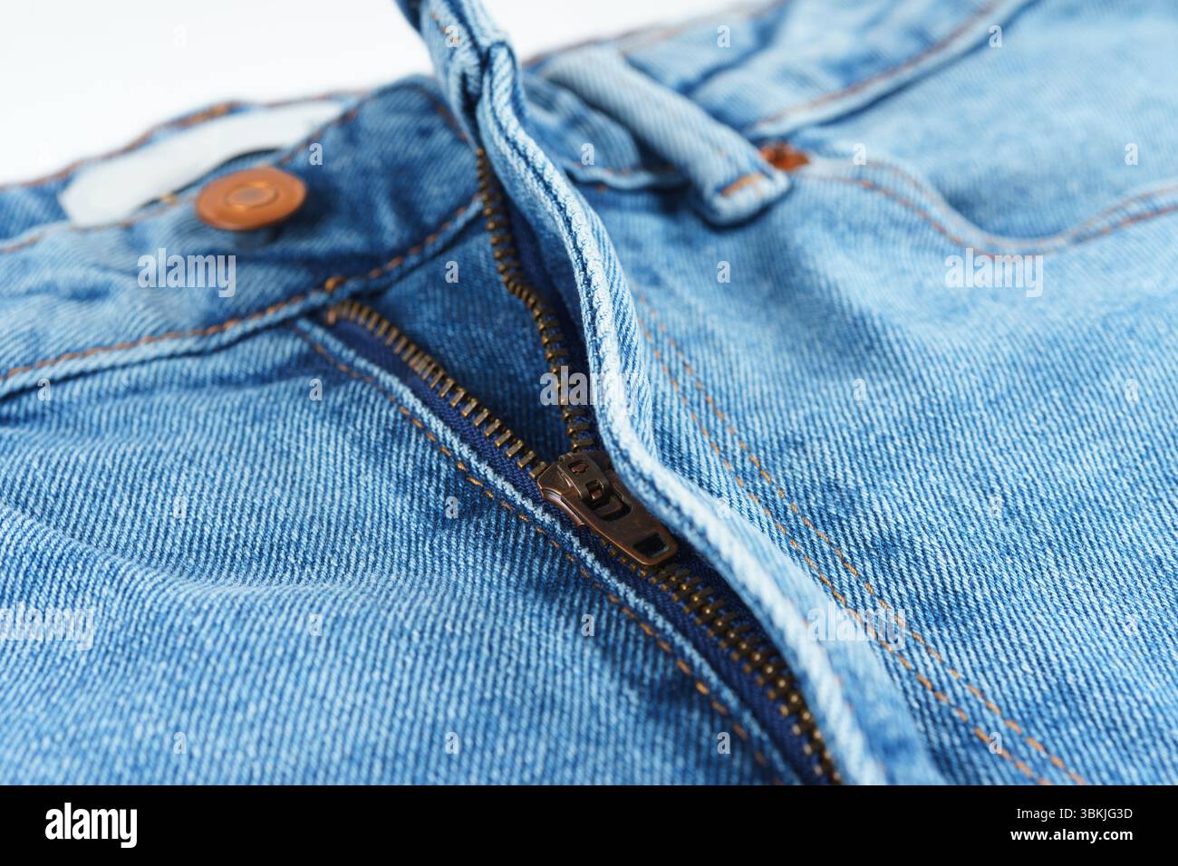 Macro photo of blue denim jeans showing metal copper button and zipper ...