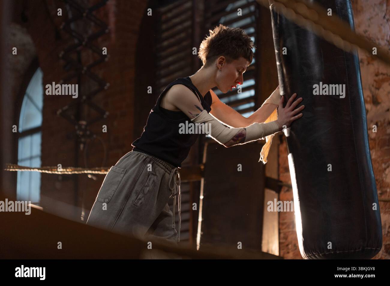 Short-haired fighter in boxing ring, cinematic rest moment between ...
