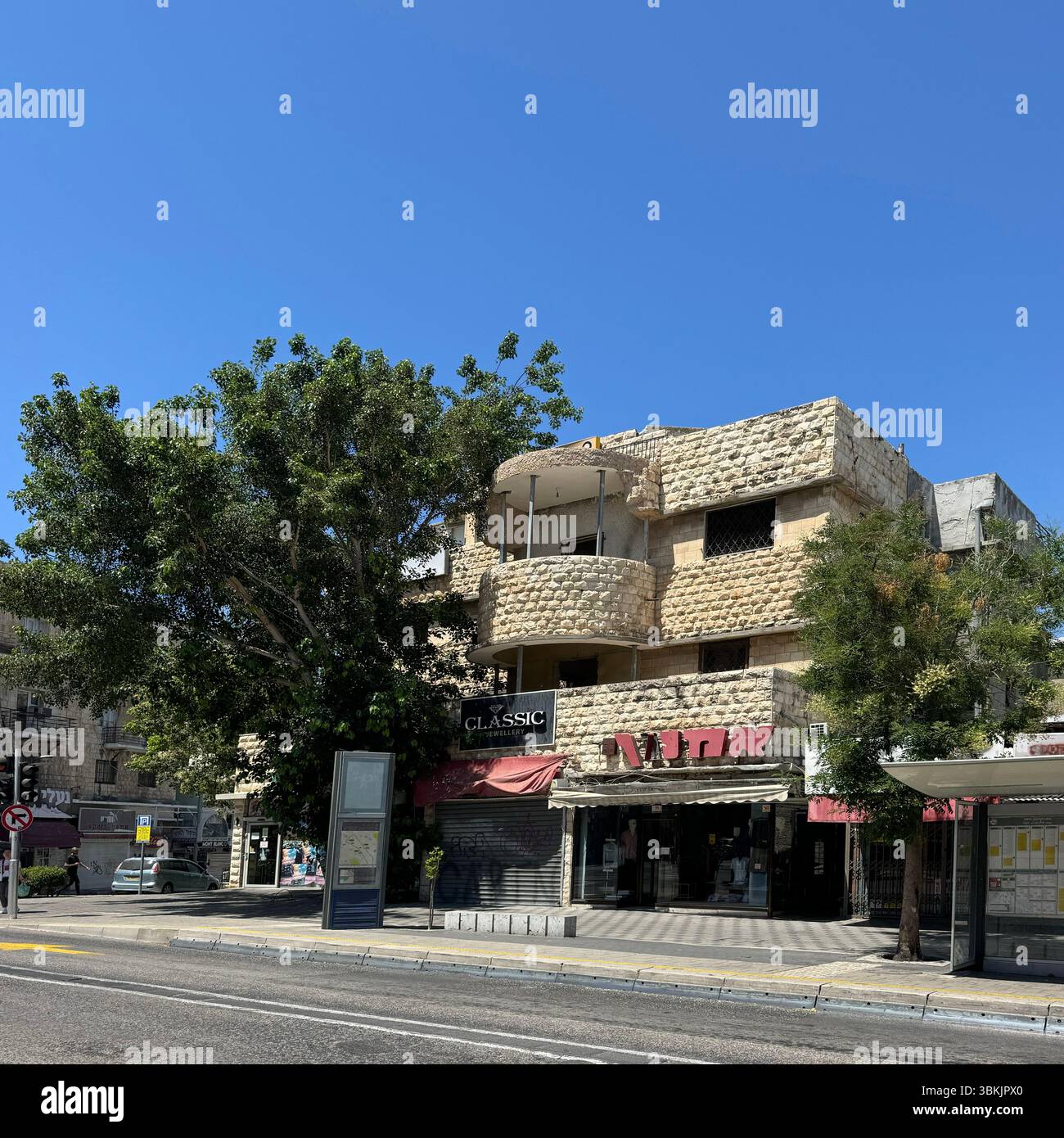 Haifa, Israel, 21 June 2025, A stone building with shops on the ground ...