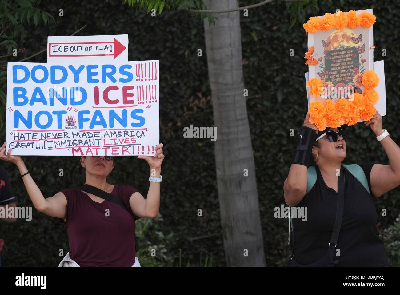 Demonstrators hold signs as they protest outside Dodger Stadium on ...