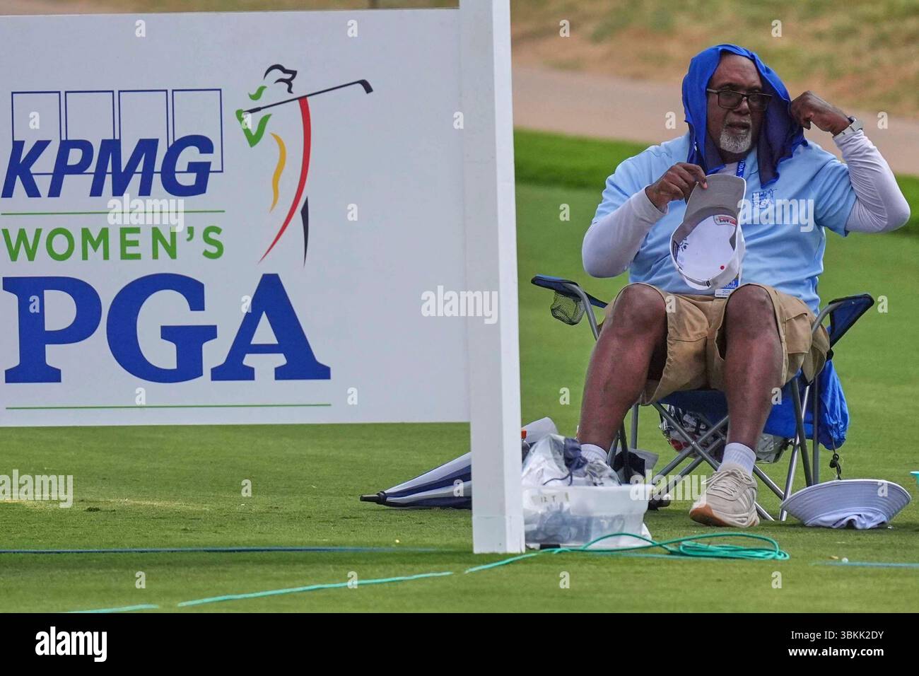 Golf marshal Tyrone Burnett uses a wet cloth to keep cool at the 16th ...