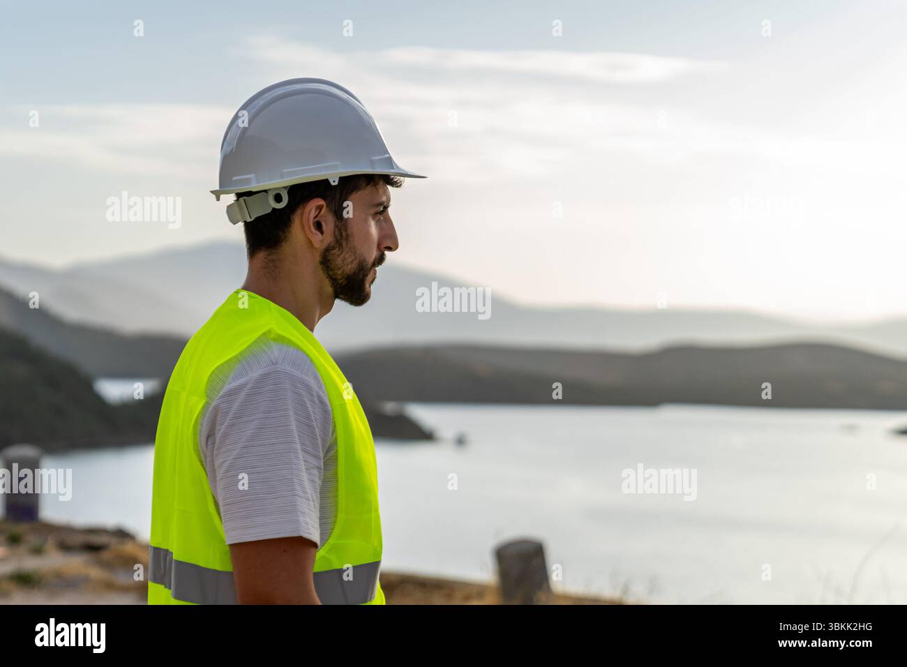 Engineer gazing with admiration at a large reservoir while supervising ...