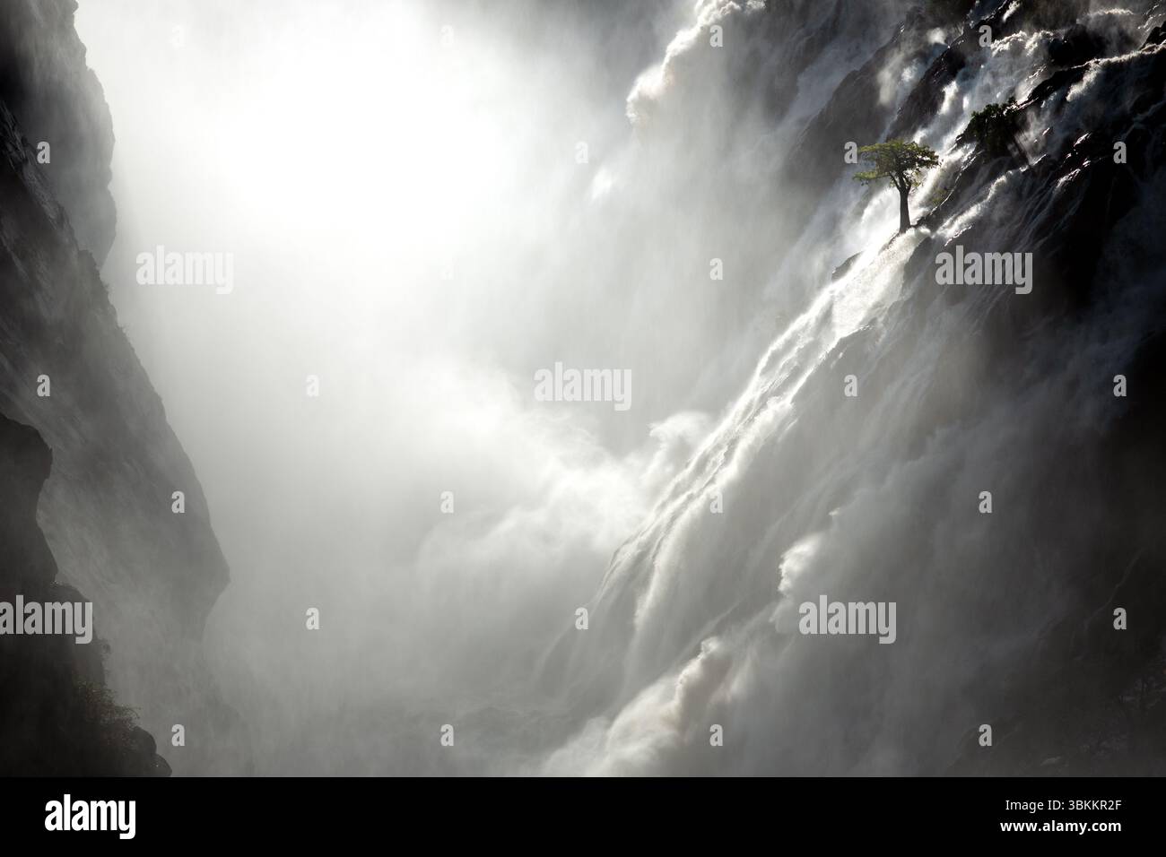 The bright light rays of a setting sun beams down into Ruacana Falls on ...